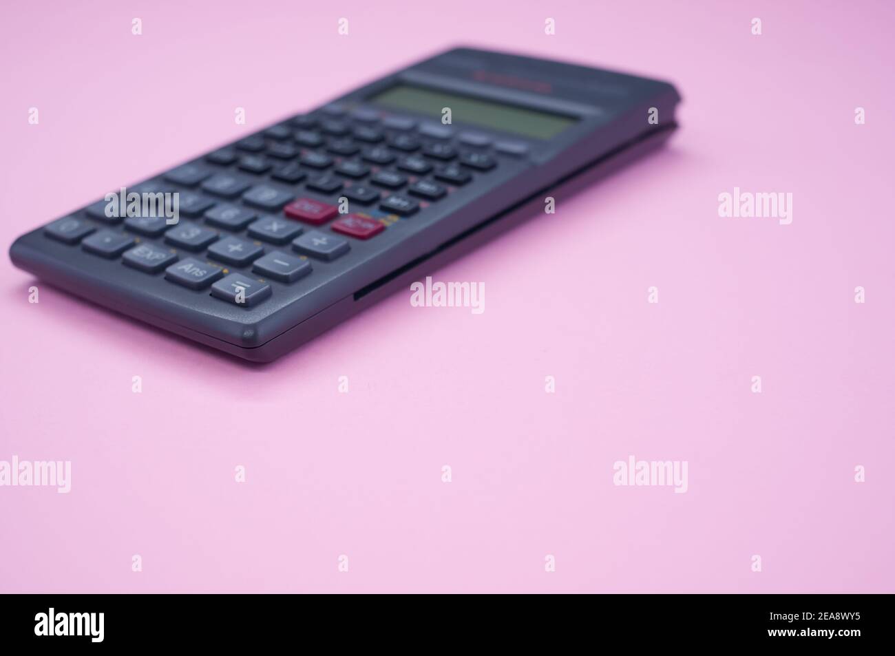Soft focus of a scientific calculator keypad on a pink surface with ...
