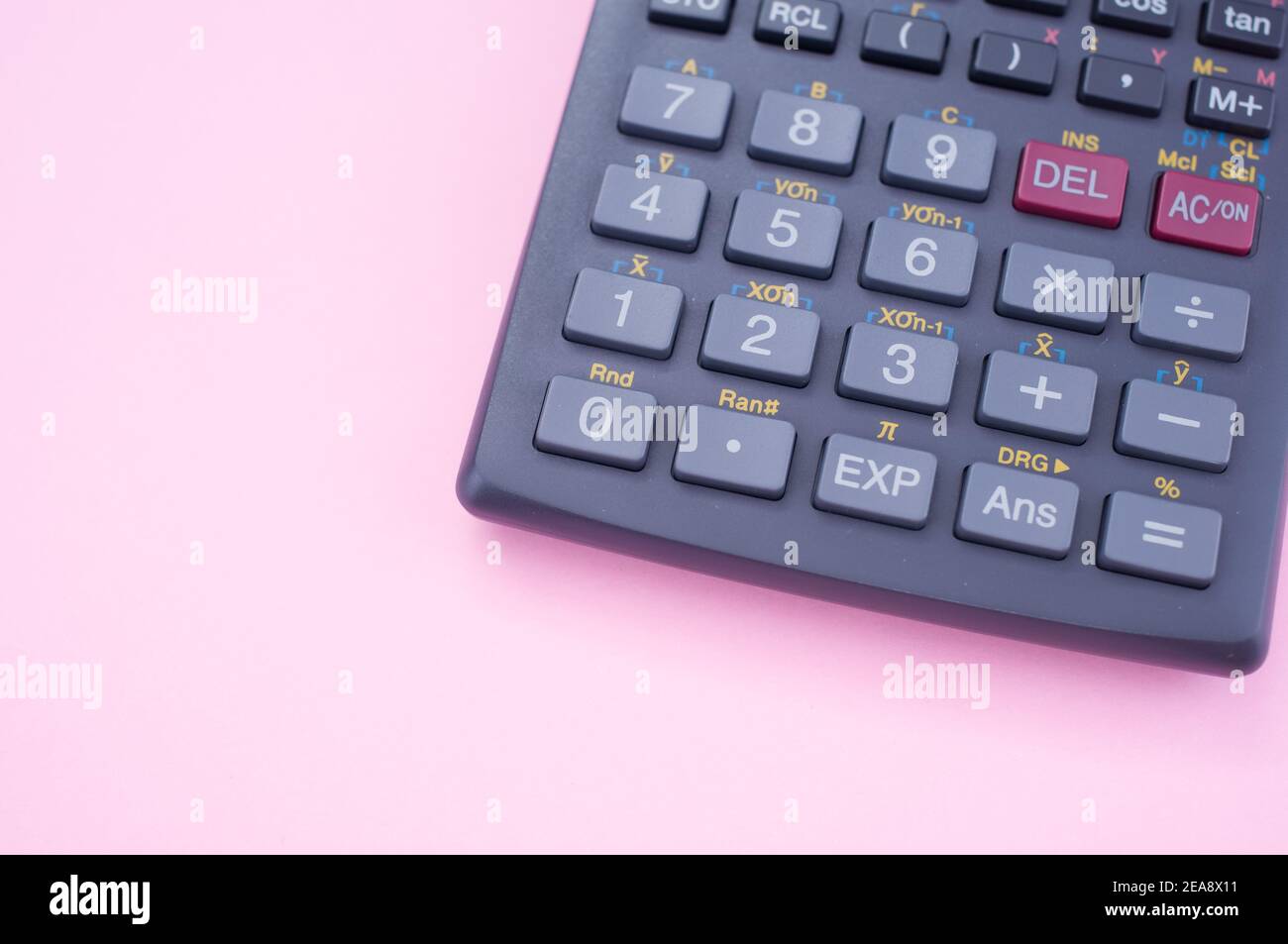 Closeup partial view of a scientific calculator keypad on a pink ...