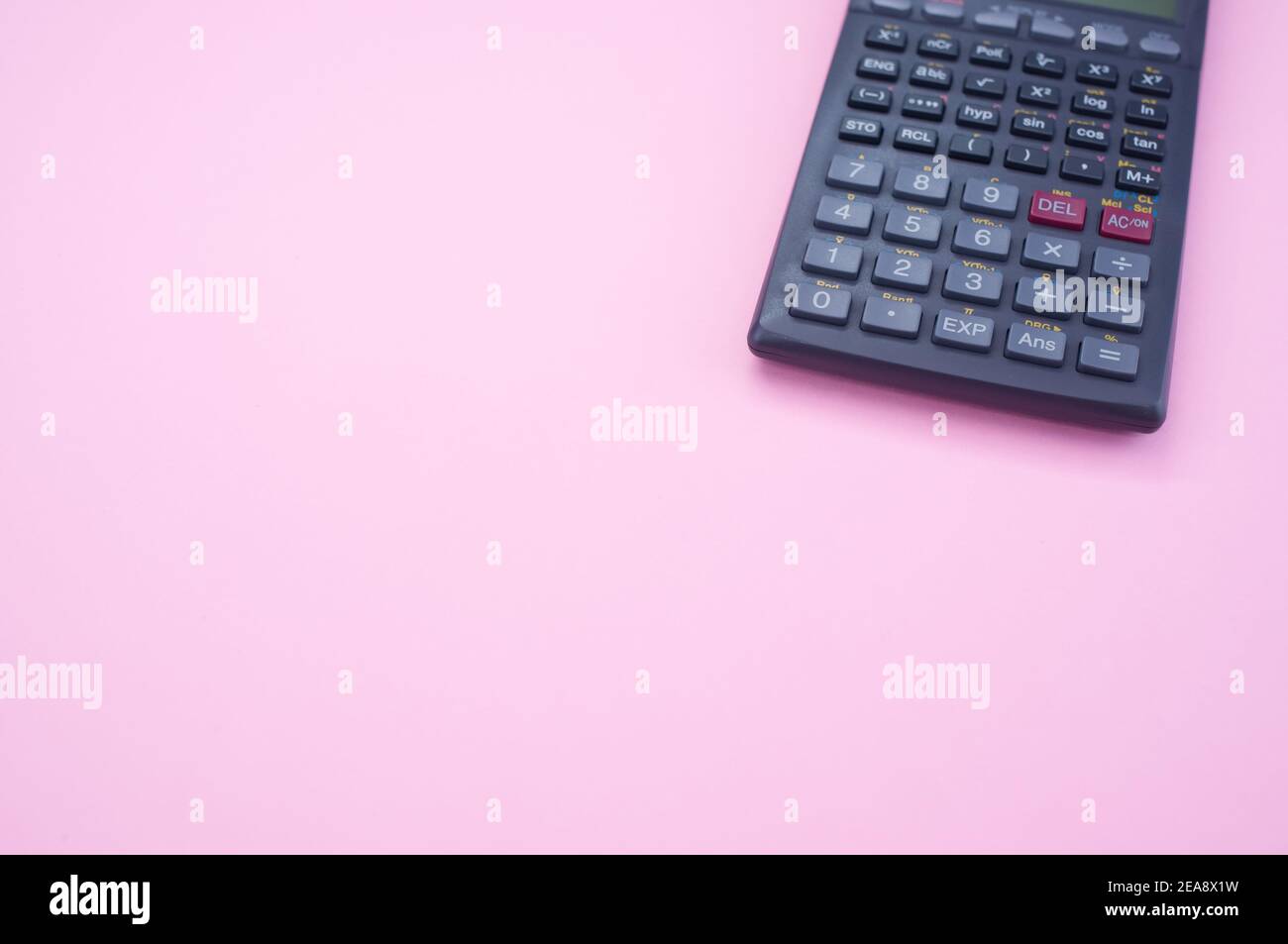 Closeup partial view of a scientific calculator keypad on a pink ...
