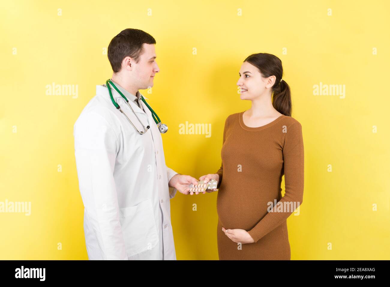 Male gynecologist gving pills to pregnant woman during appointment at ...