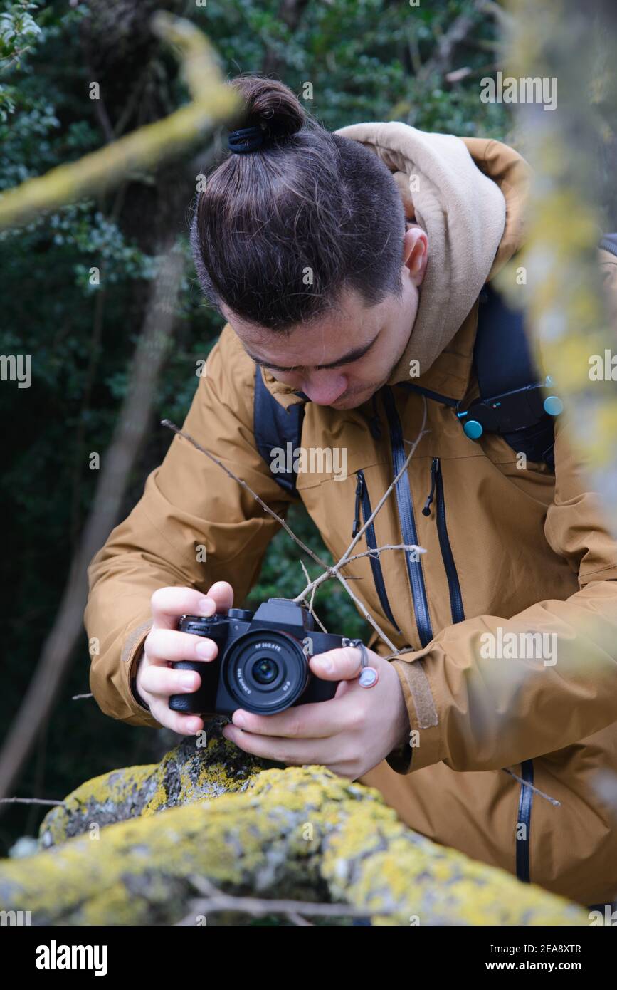 Vertical shot of a photographer taking pictures of plants and trees ...
