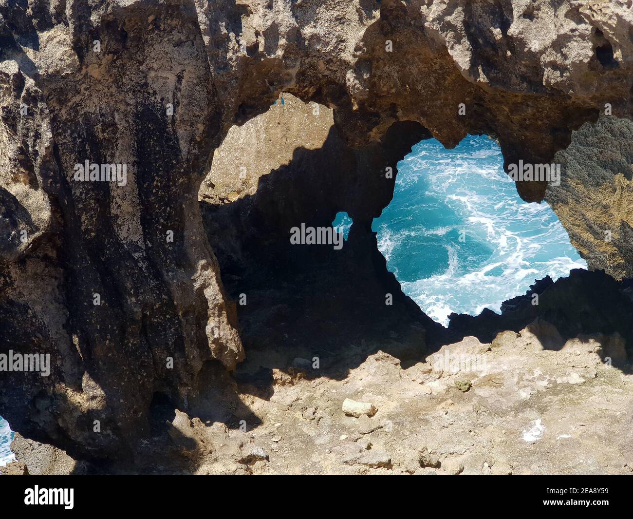 Clear blue sea through rocky frame Stock Photo - Alamy