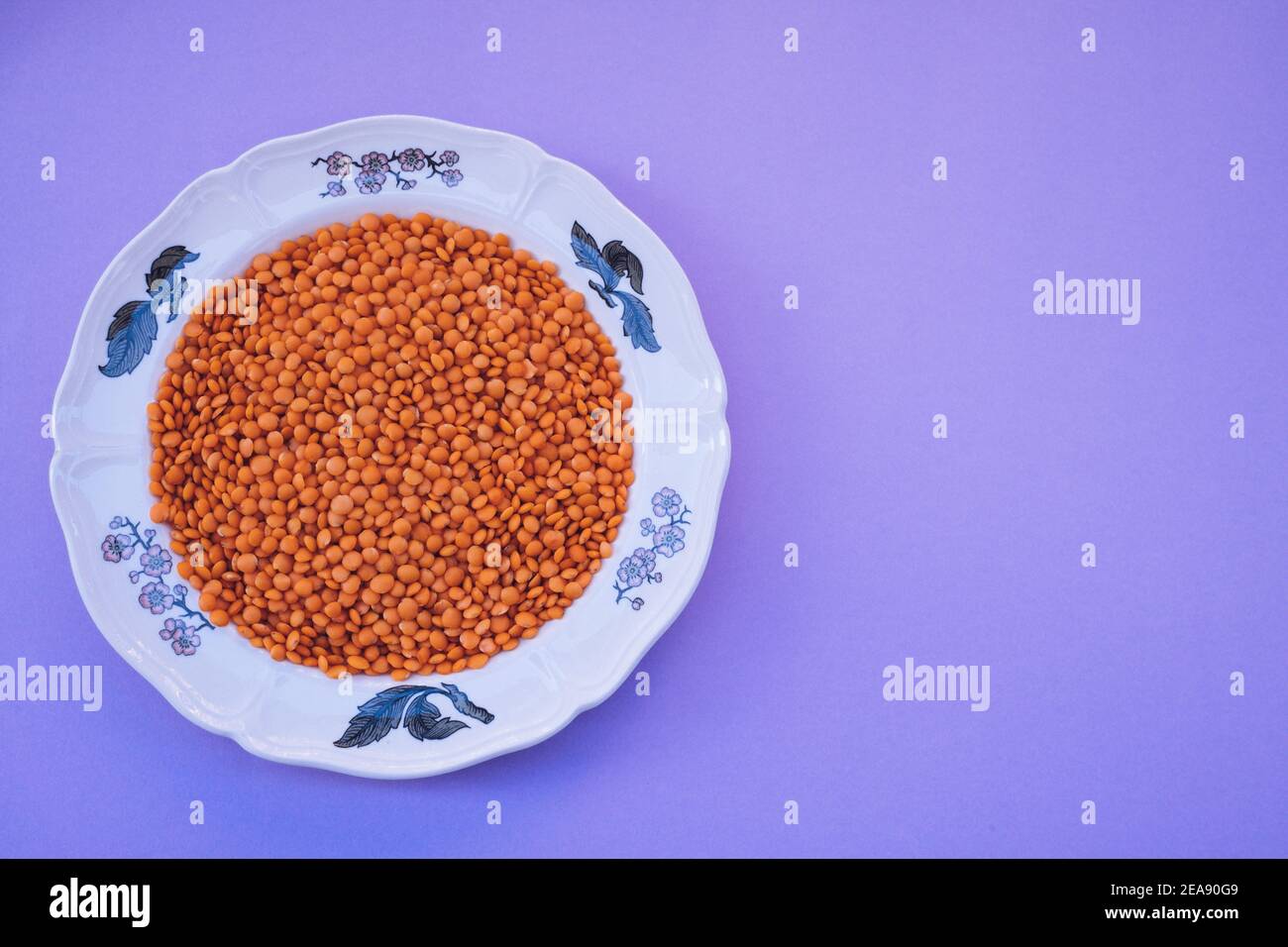 Red lentils on the vintage plate on the violet background Stock Photo ...