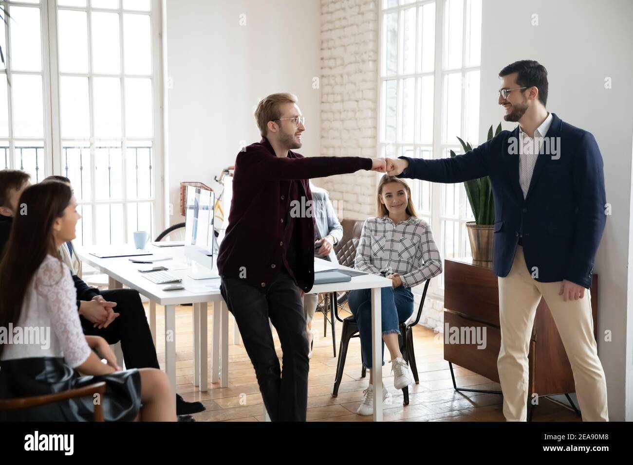 Happy employee congratulating colleague on work achievement Stock Photo ...