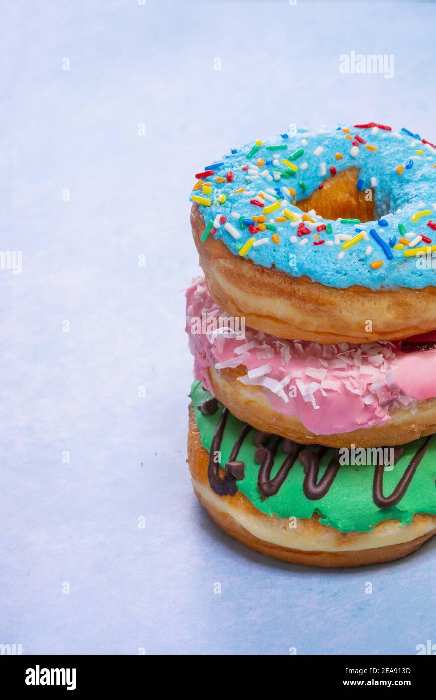 Vertical shot of colorful donut on blue background Stock Photo - Alamy