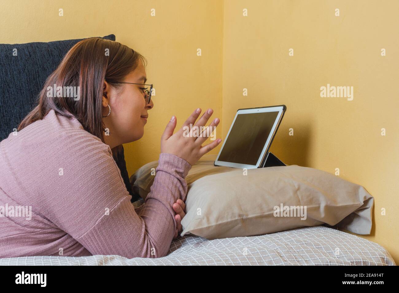 Latin woman making a video call with her tablet the black screen ...