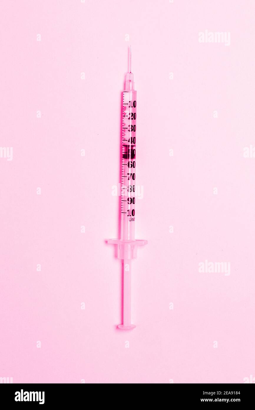 Medical syringe with liquid on a pink background. Beauty injections ...