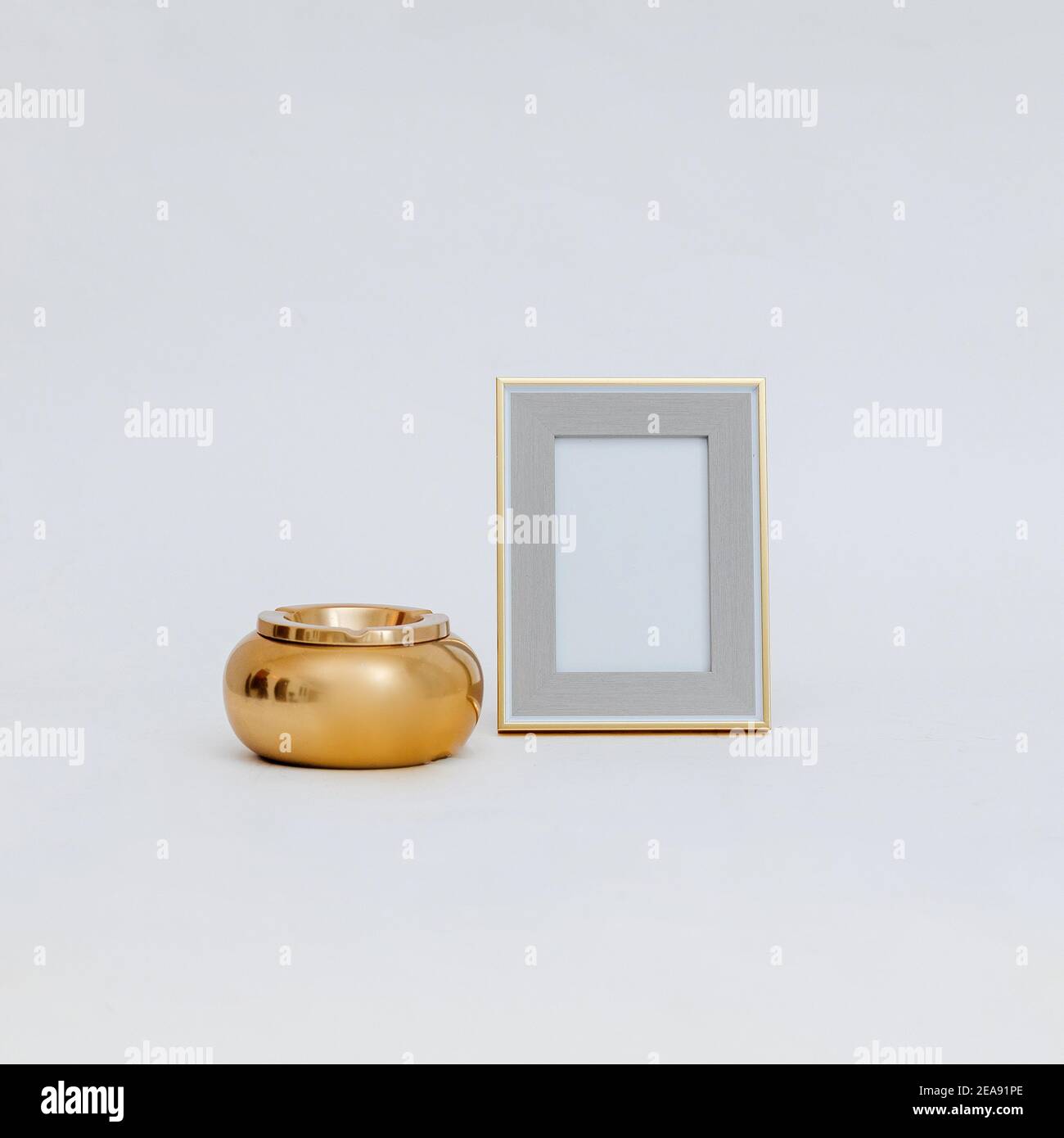 Closeup shot of a golden ashtray next to a picture frame Stock Photo ...