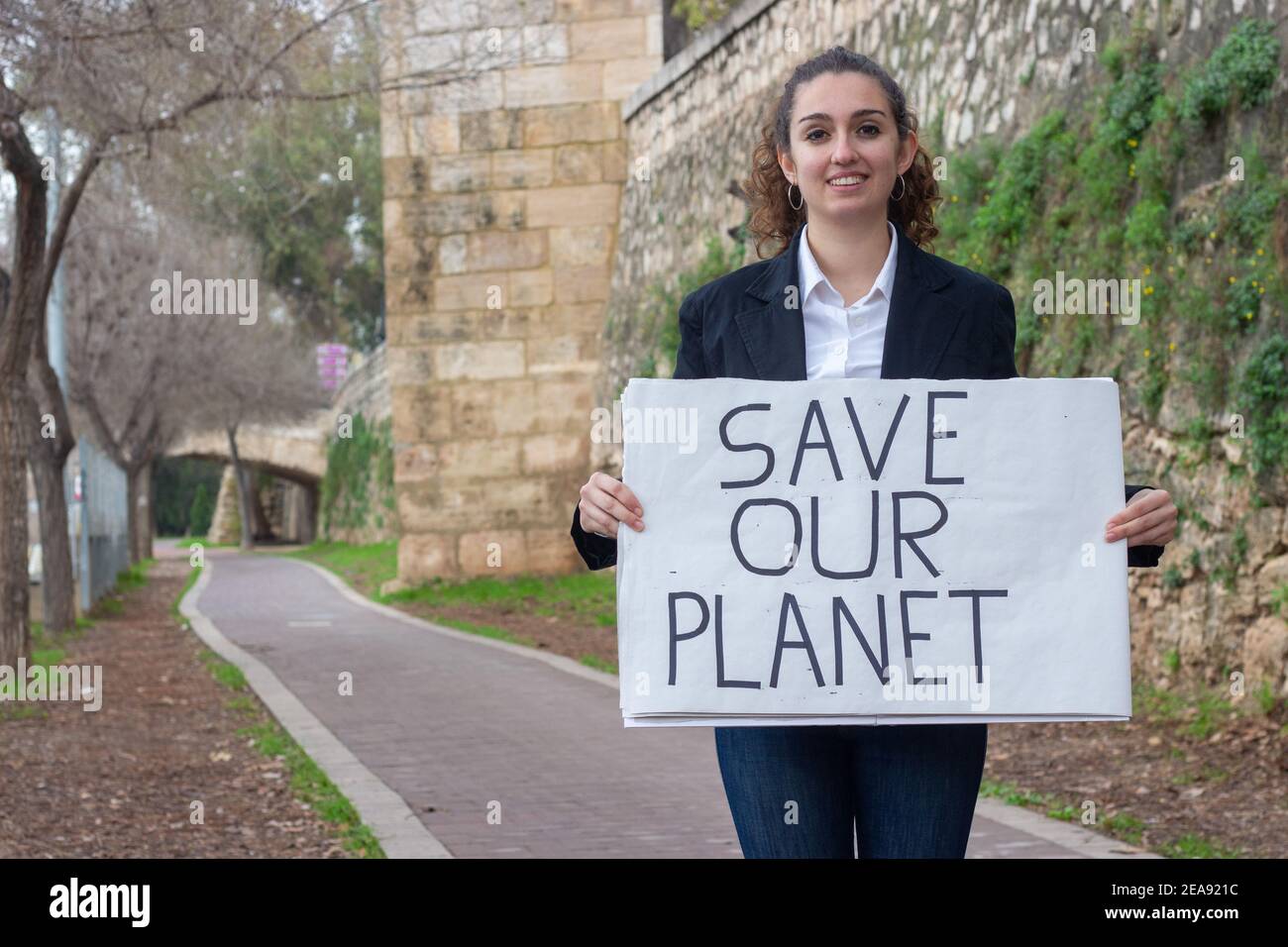 Young female holding a sign saying 'save our planet' Stock Photo - Alamy