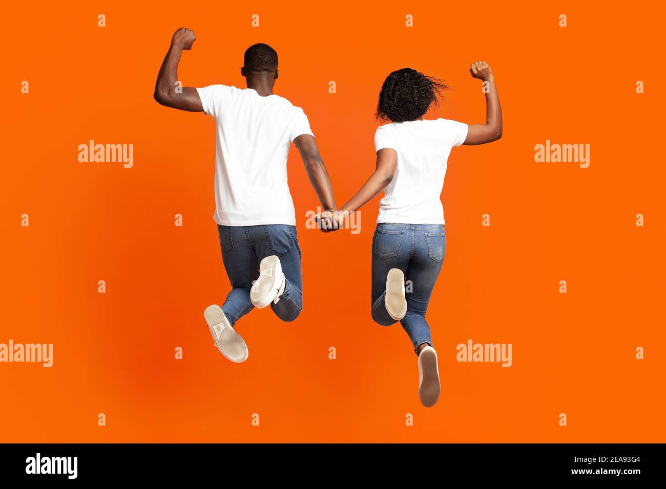 Back view of african couple jumping up Stock Photo - Alamy