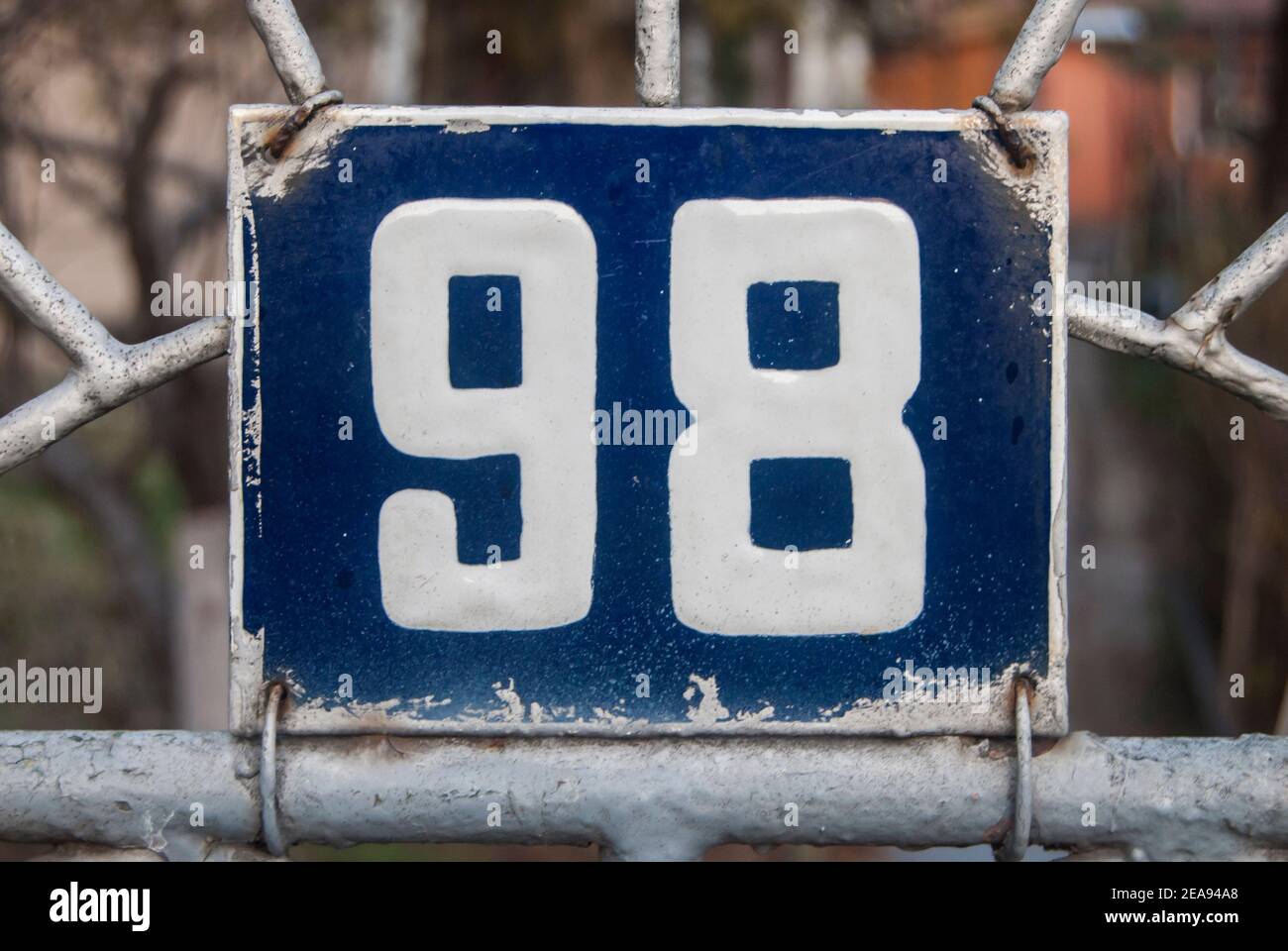 Weathered grunge square metal enamelled plate of number of street ...