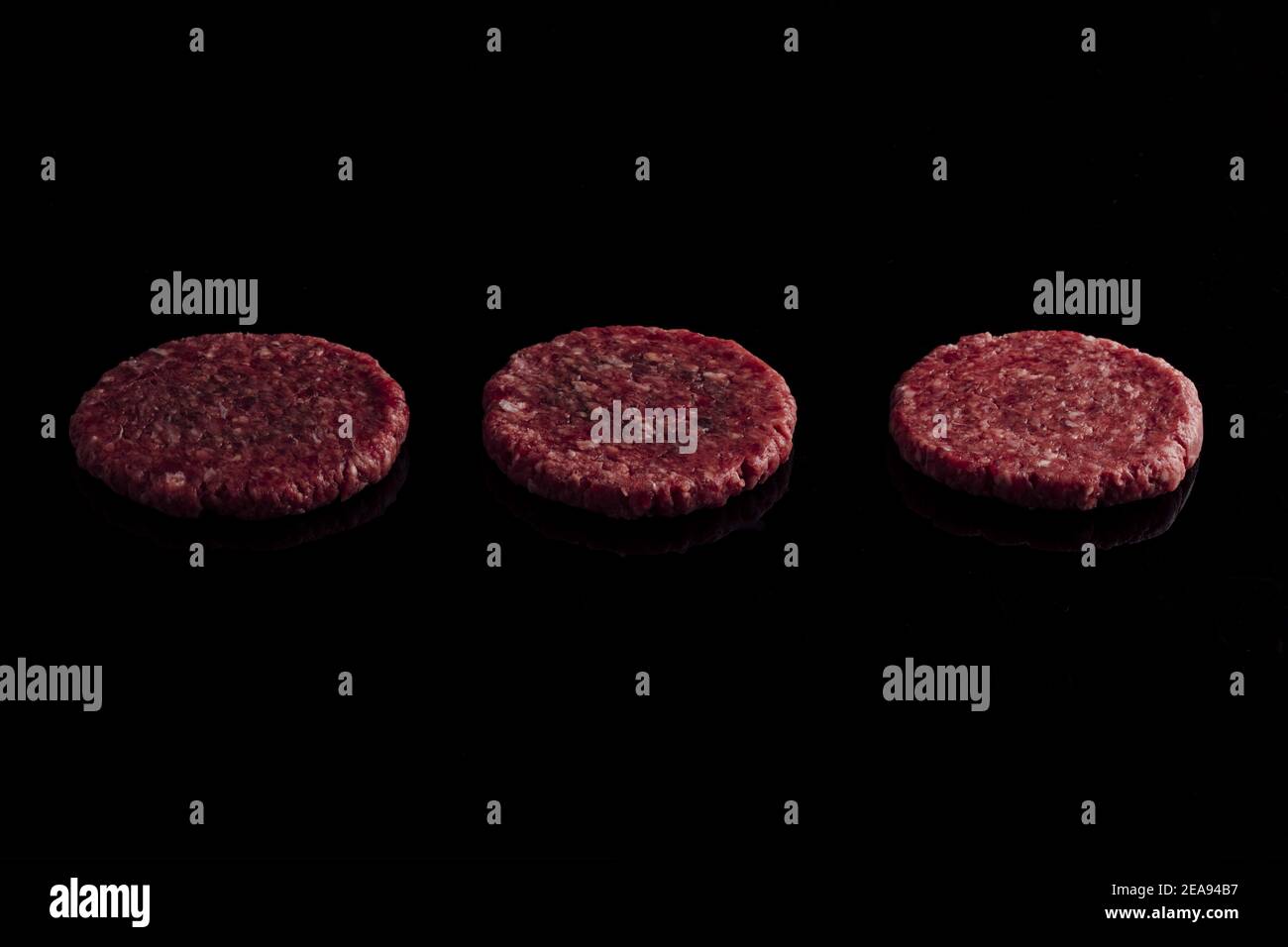 Closeup shot of fresh raw burger patties on a black surface Stock Photo ...