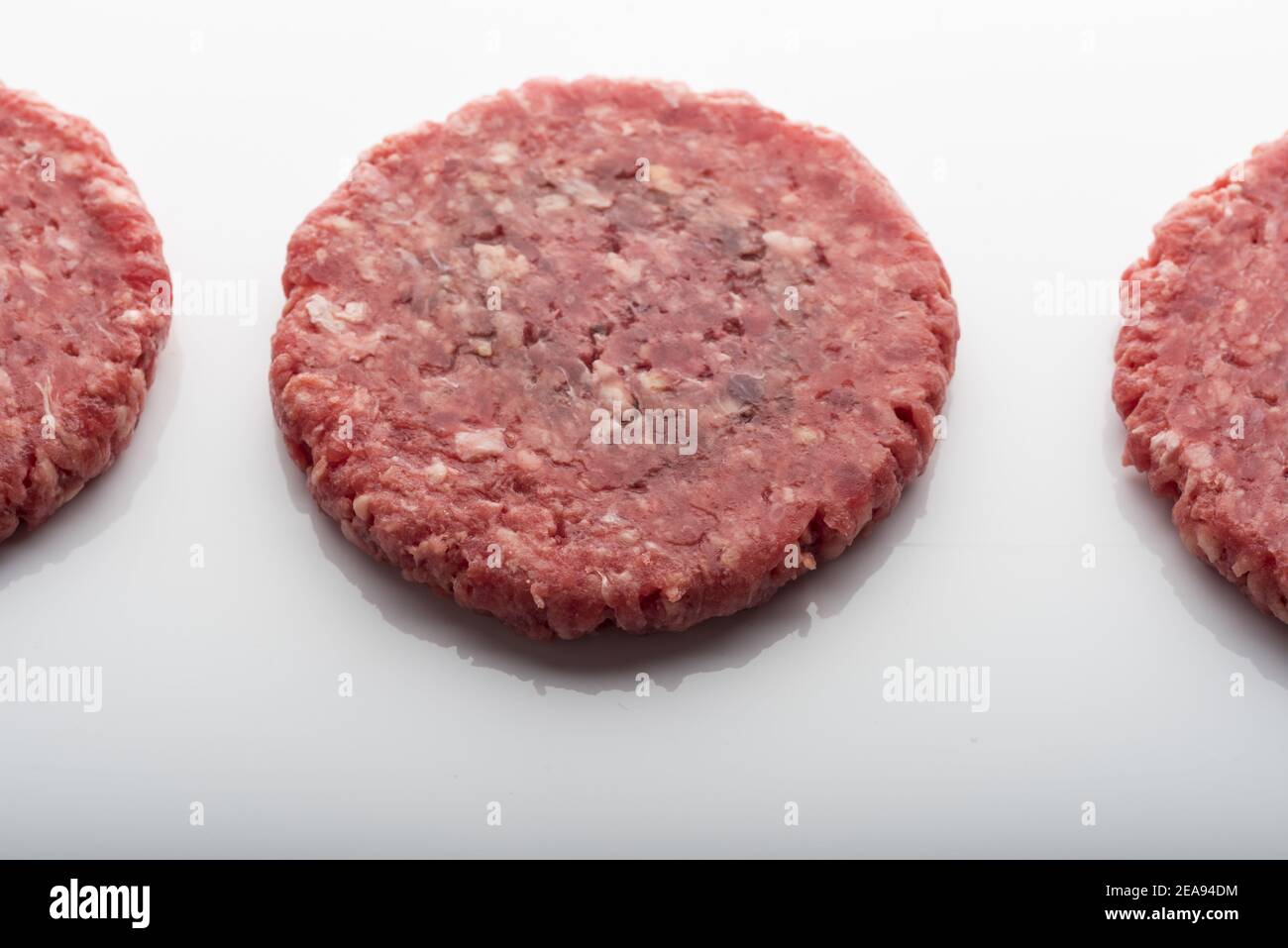 closeup shot of fresh raw burger patties on a white surface Stock Photo ...