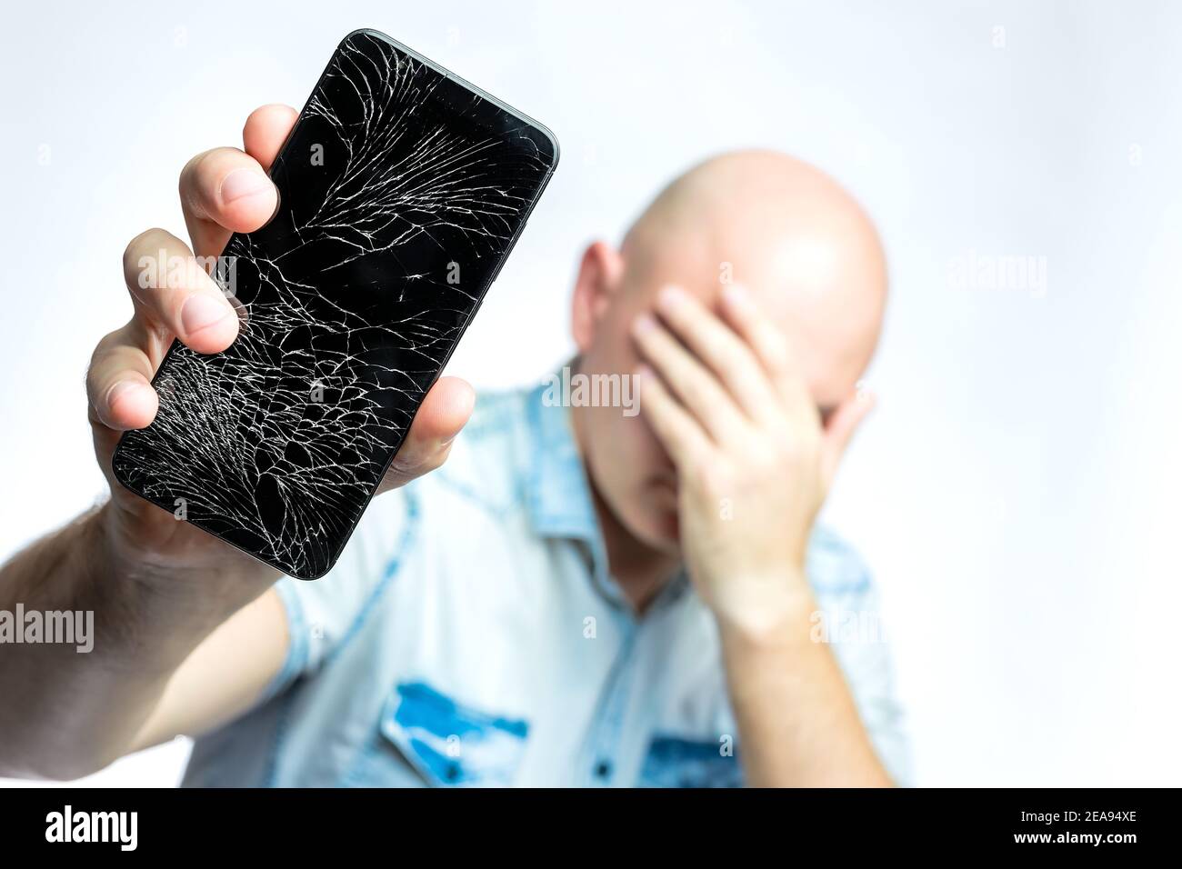 Phone With A broken screen close-up. A white man is holding a black ...