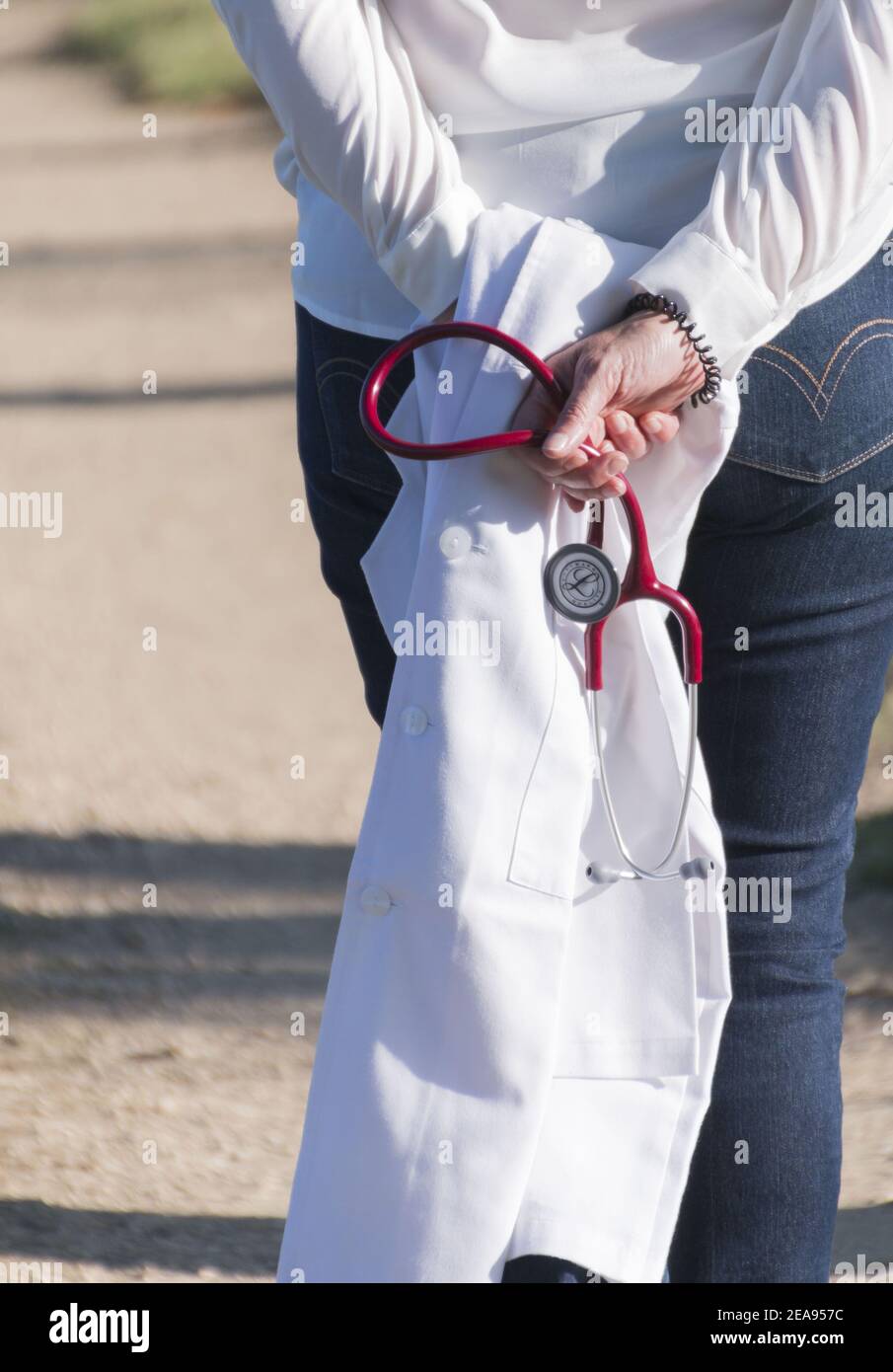 Vertical shot of a doctor holding the white uniform and a stethoscope ...