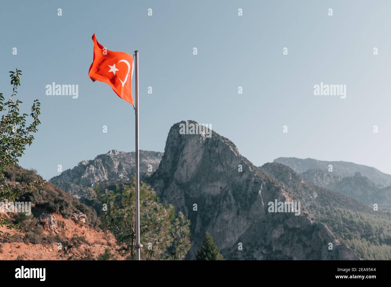 Turkish flag waving in the wind with Taurus mountains on the background ...