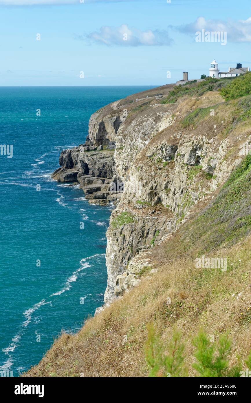 Anvil Point Lighthouse, on cliff top above the Tilly Whim Caves, viewed ...