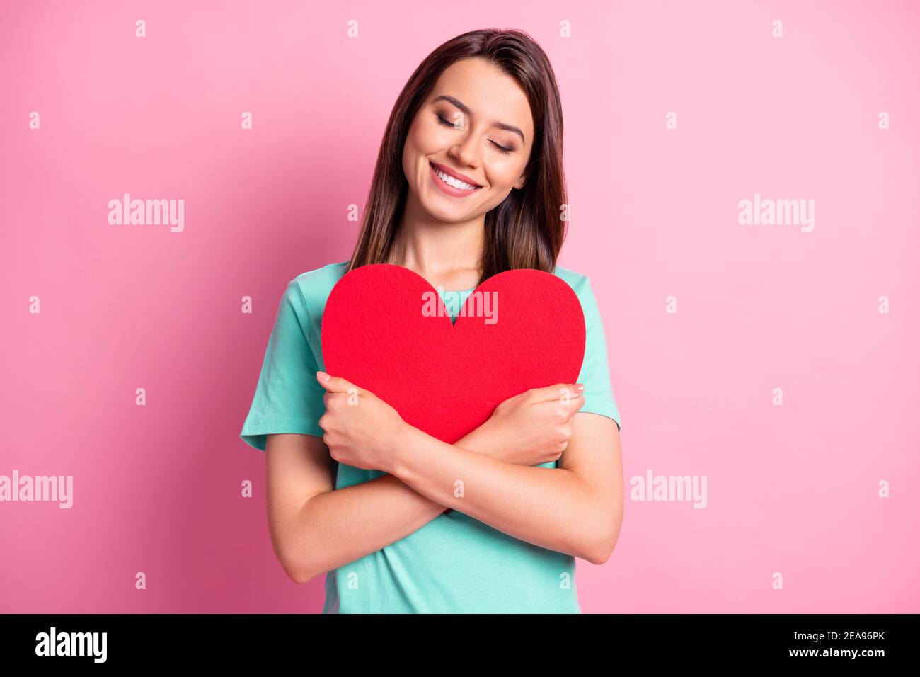 Photo portrait of relaxed woman hugging big red heart card with closed ...