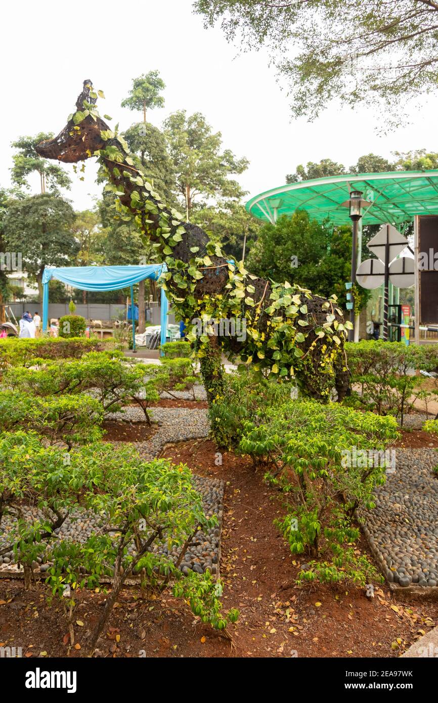 An ornamental giraffe made of wire and green plants in a housing ...