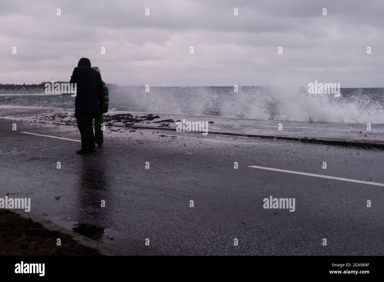 Strande, Germany. 08th Feb, 2021. Waves crash against a quay wall and ...