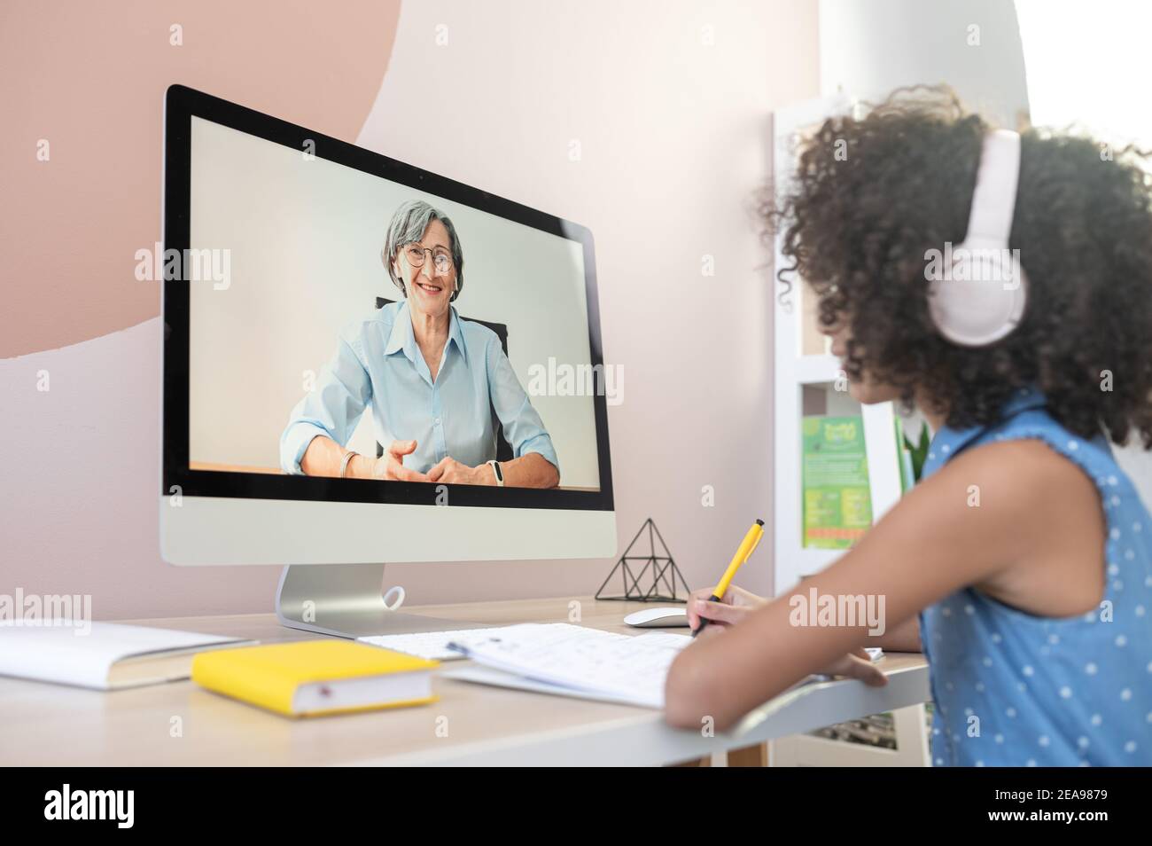 E-learning concept. Cute little multiracial girl watching video classes ...