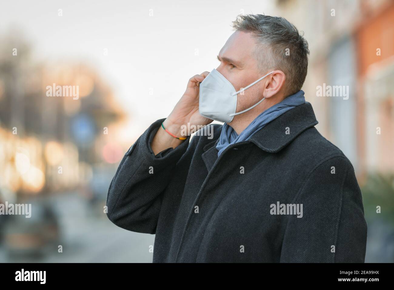 Man wearing protection mask walking on a city street Stock Photo - Alamy