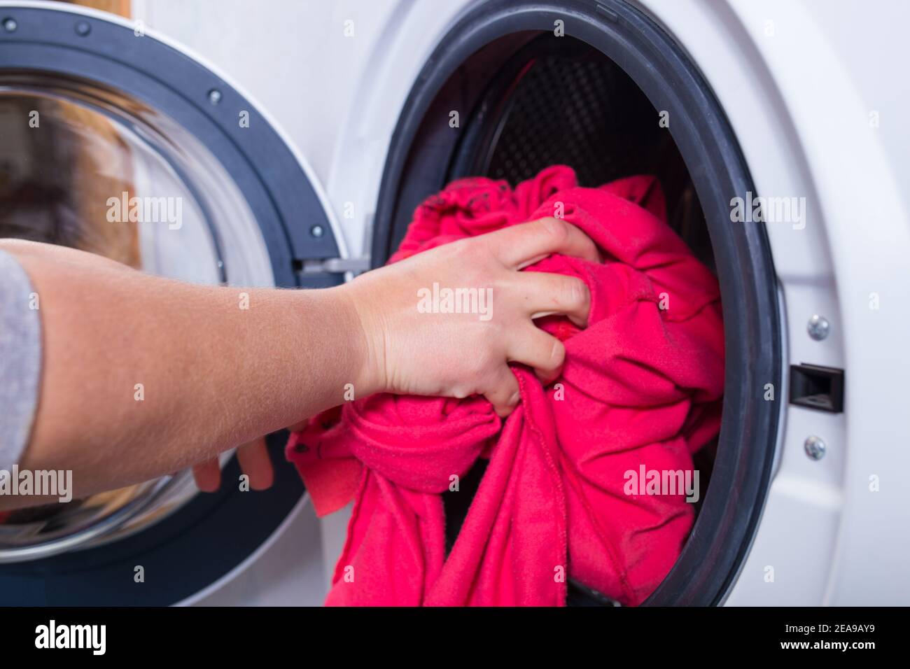 Woman putting towel washing machine hi-res stock photography and images ...