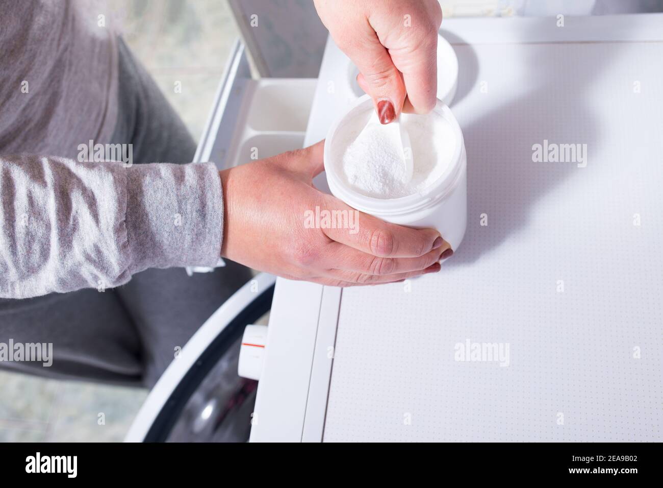 Woman's hands loading washing powder to the washing machine before ...