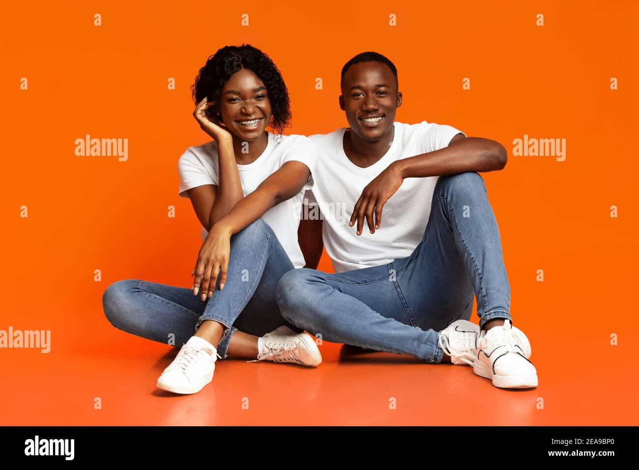 Cute black couple sitting on floor together Stock Photo - Alamy