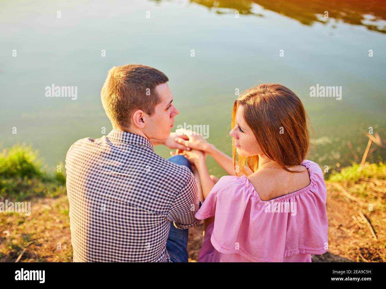 Enjoying By The River.Romantic smiling couple in love dating at sunset ...