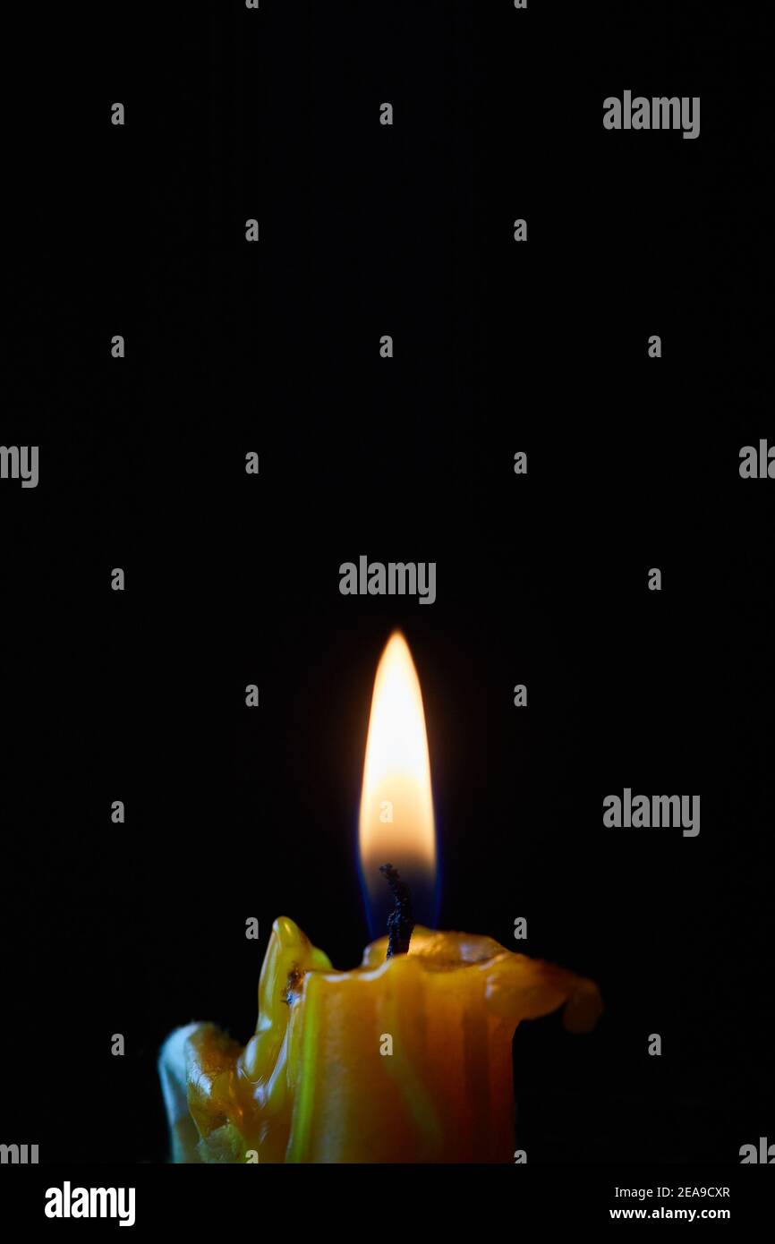Single candle light on a black background. Burning candle close up ...