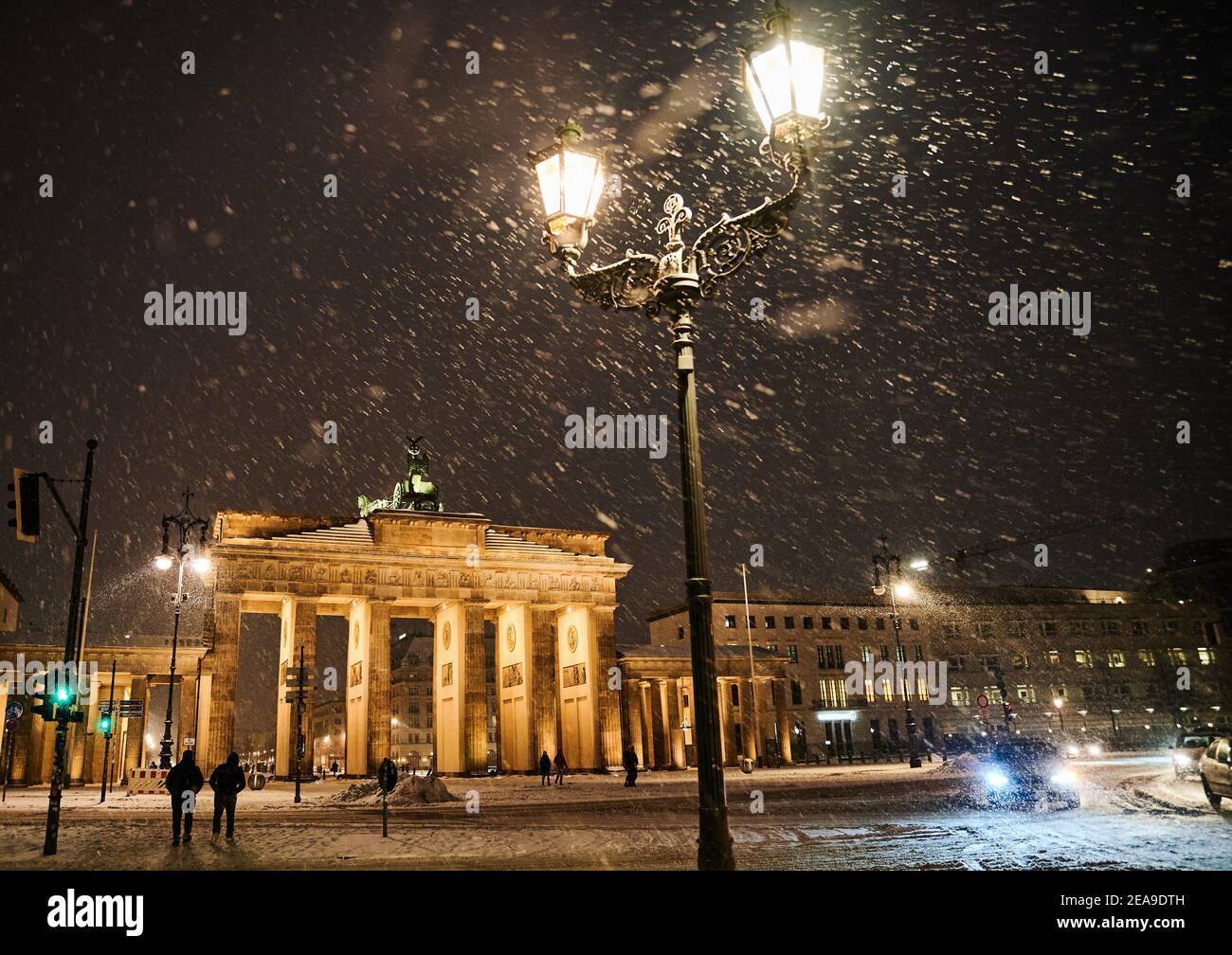 Berlin, Germany. 08th Feb, 2021. Snow falls in the dark in front of the ...