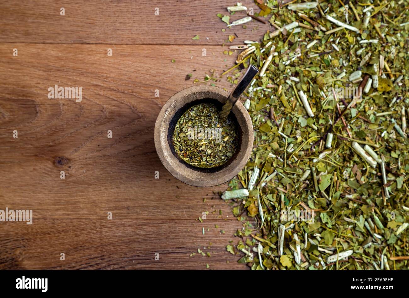 Traditional mate made of calabash over a wooden table with yerba mate ...