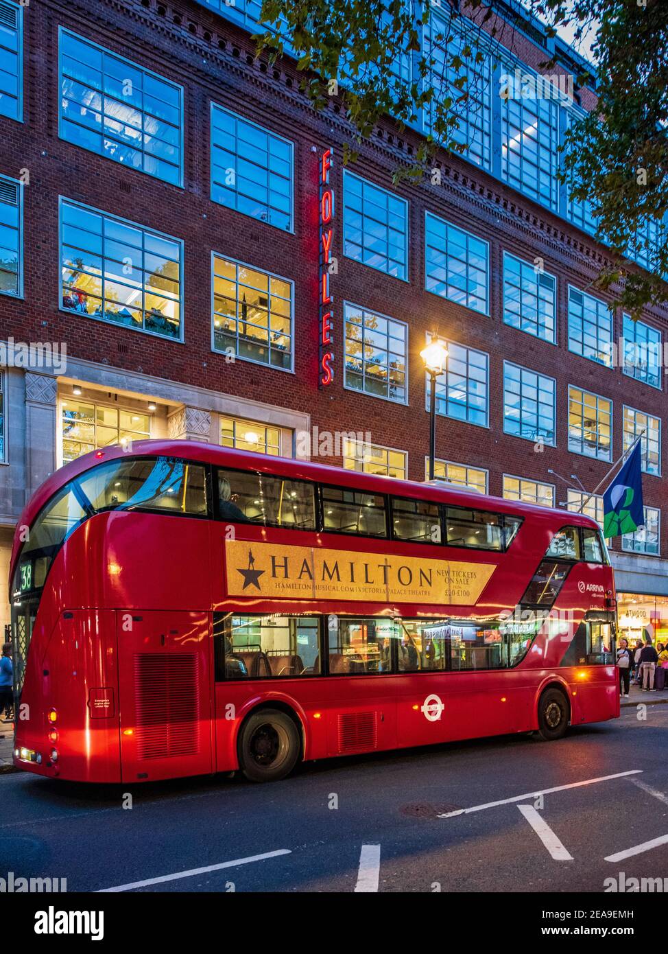 A red London bus stops outside Foyles Bookshop. Foyles bookshop ...