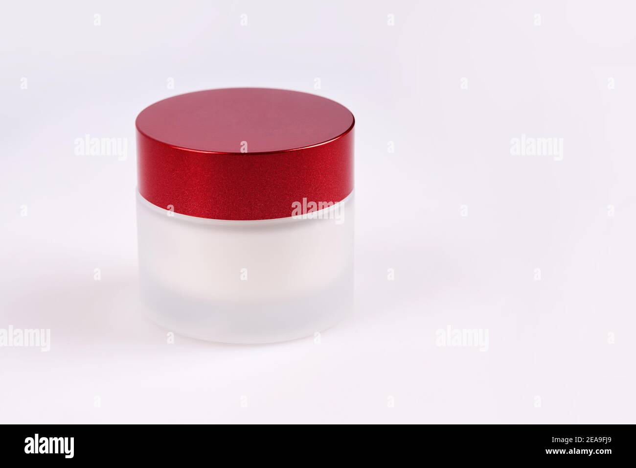Glass jar with red lid of moisturizing facial cream isolated on white ...