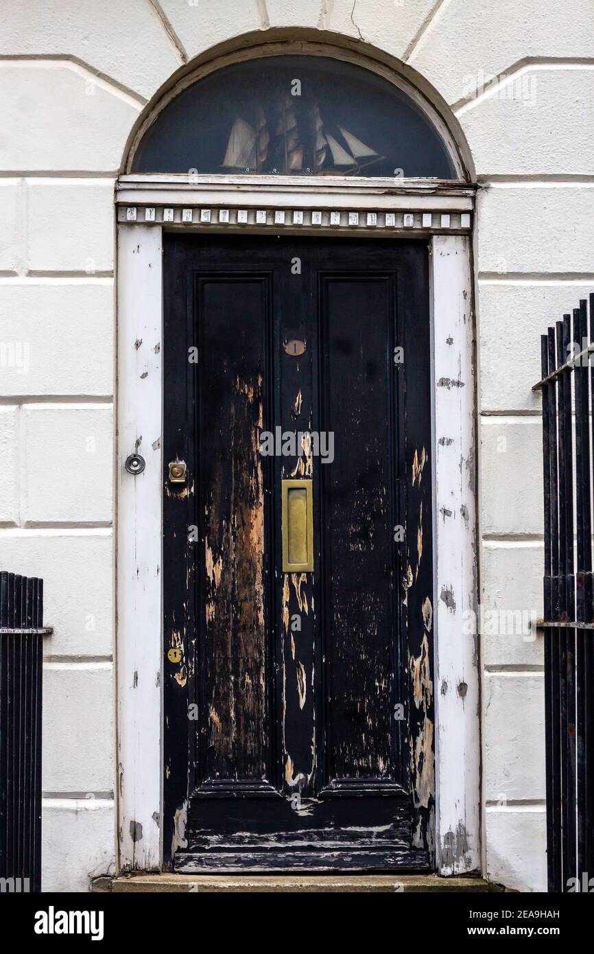 Old black door with sailing ship and black metal railings Stock Photo ...