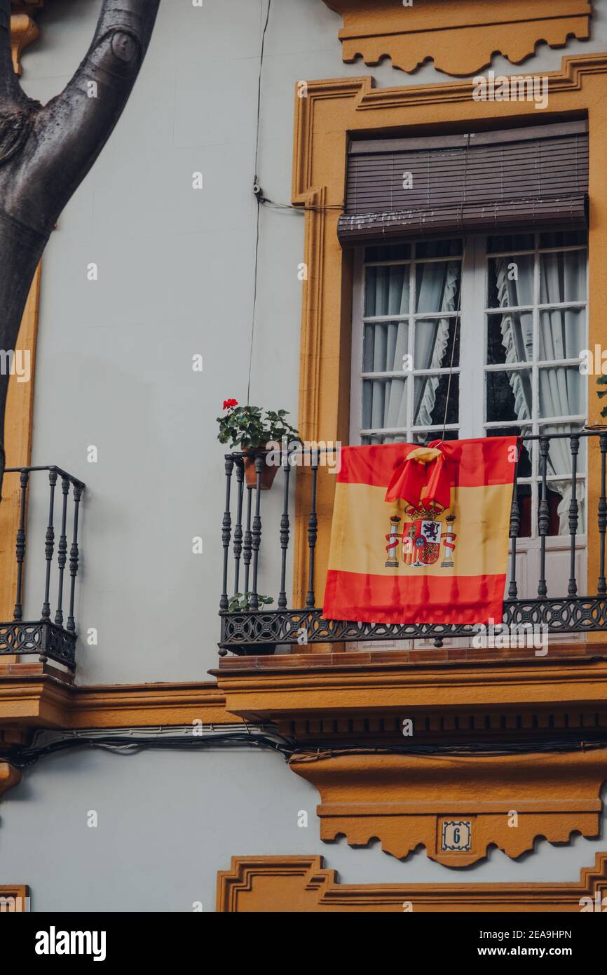 Spanish flag handing on balcony railings of a traditional building in ...