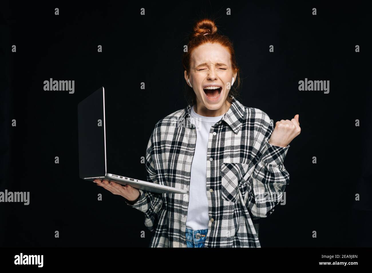 Successful happy shocked young woman with open mouth and closed eyes ...