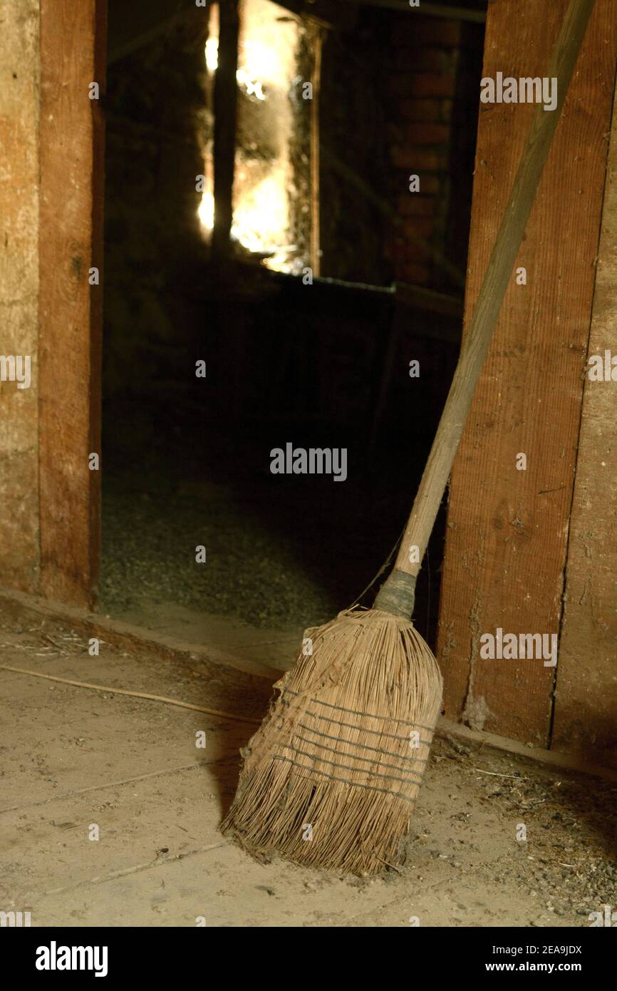 Vertical shot of an old broom leaned on the wall of a barn Stock Photo ...