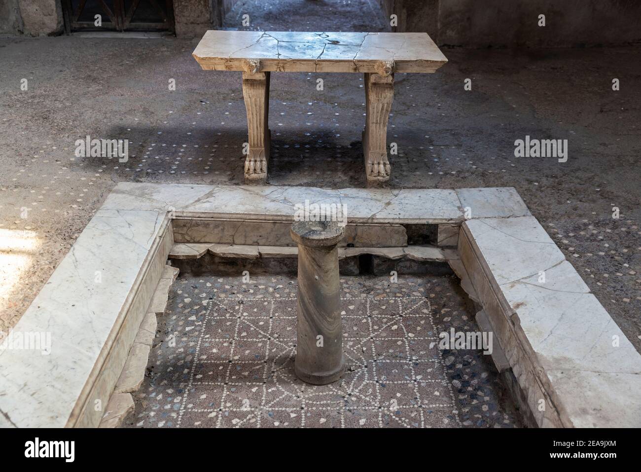 Interior of a house with a fountain and a marble table in the roman ...