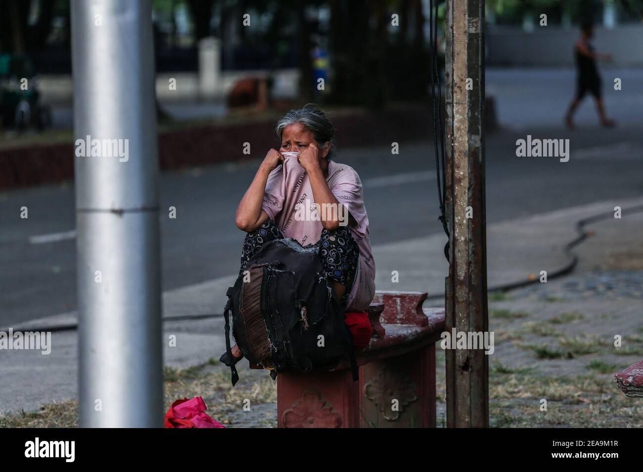 A homeless woman sits on the roadside during the coronavirus lockdown ...