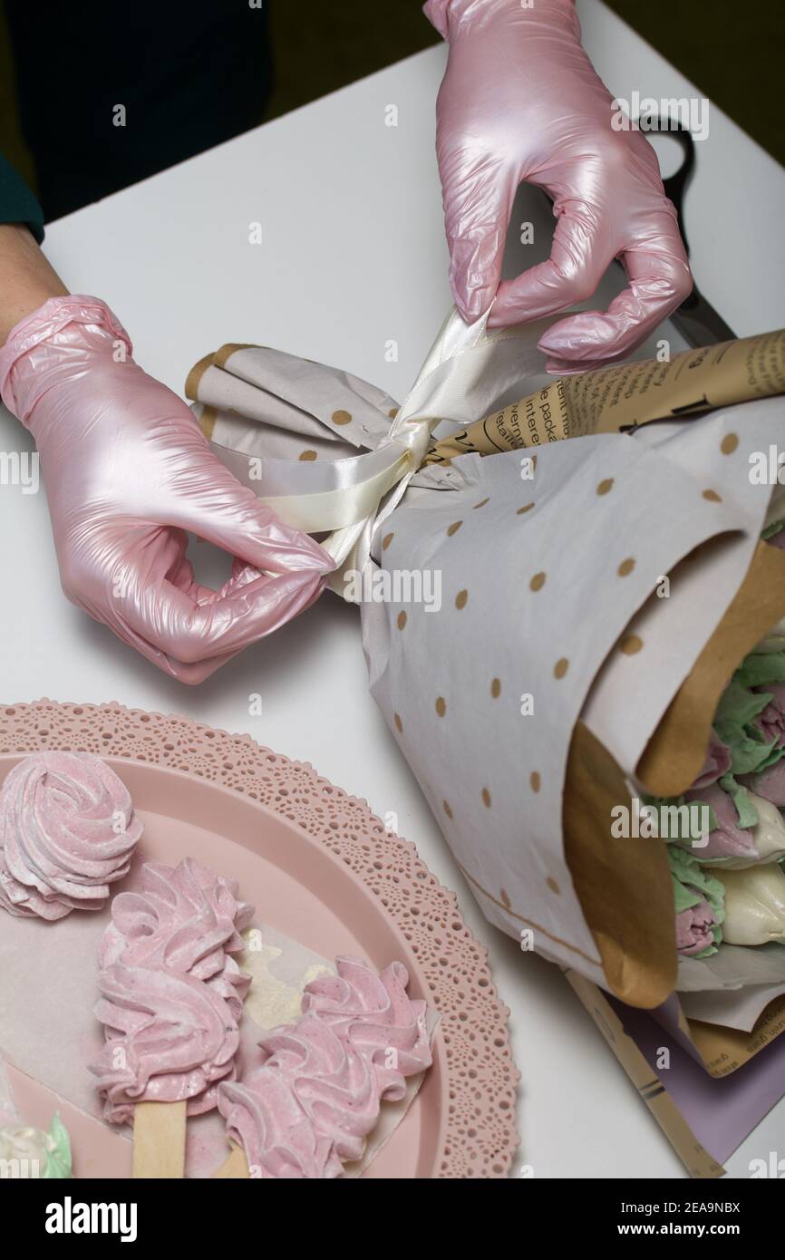 Woman makes a marshmallow bouquet. Marshmallow tulips are collected in ...