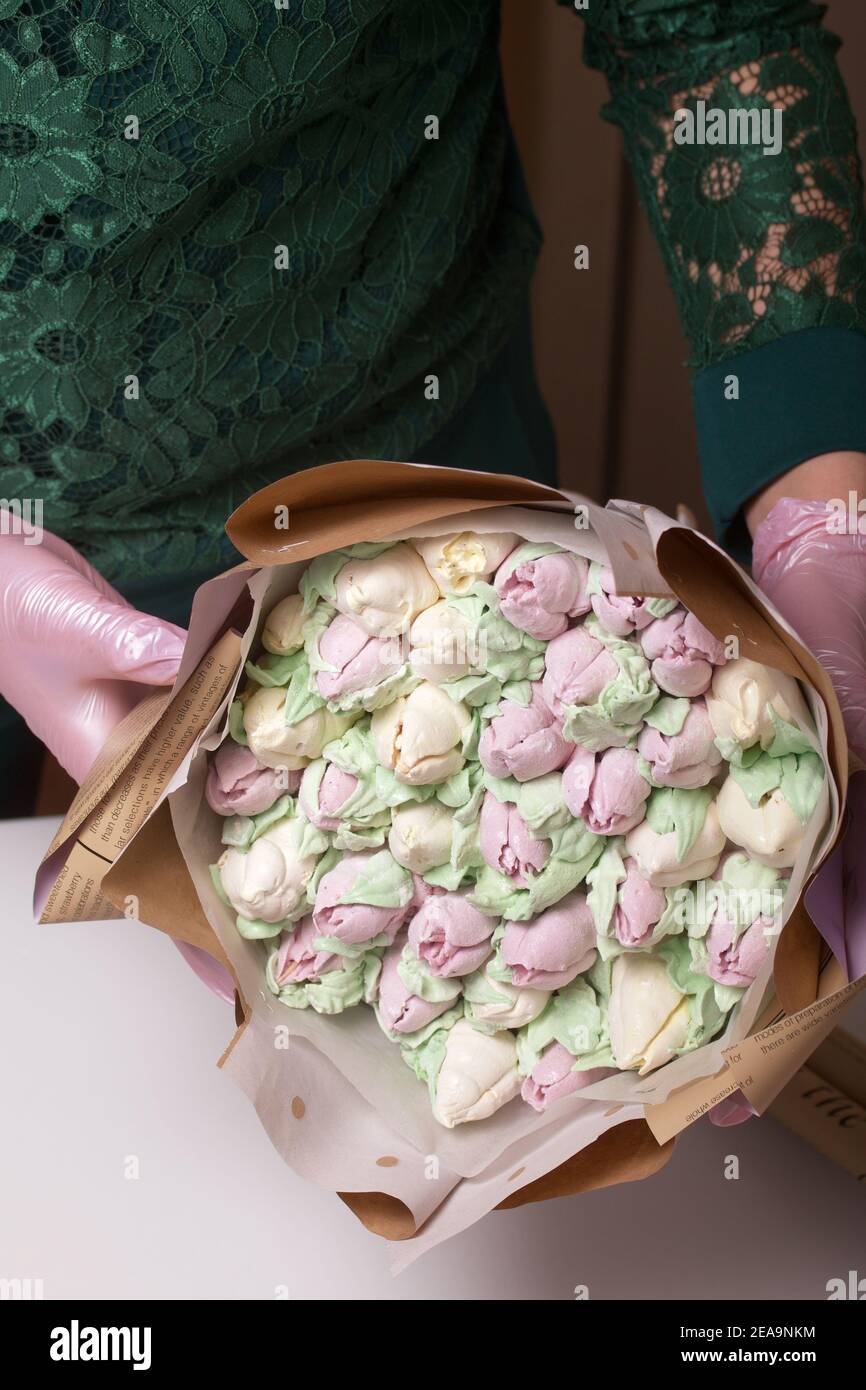 Woman makes a marshmallow bouquet. Marshmallow tulips are collected in ...