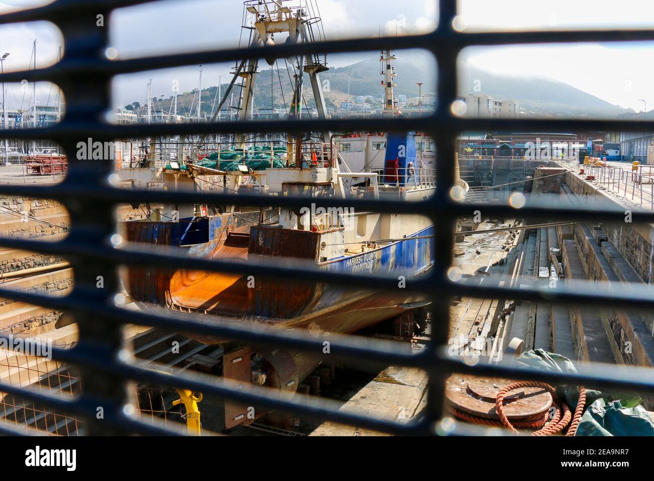 Old naval industrial ship in port/hangar for inspection behind bars of ...