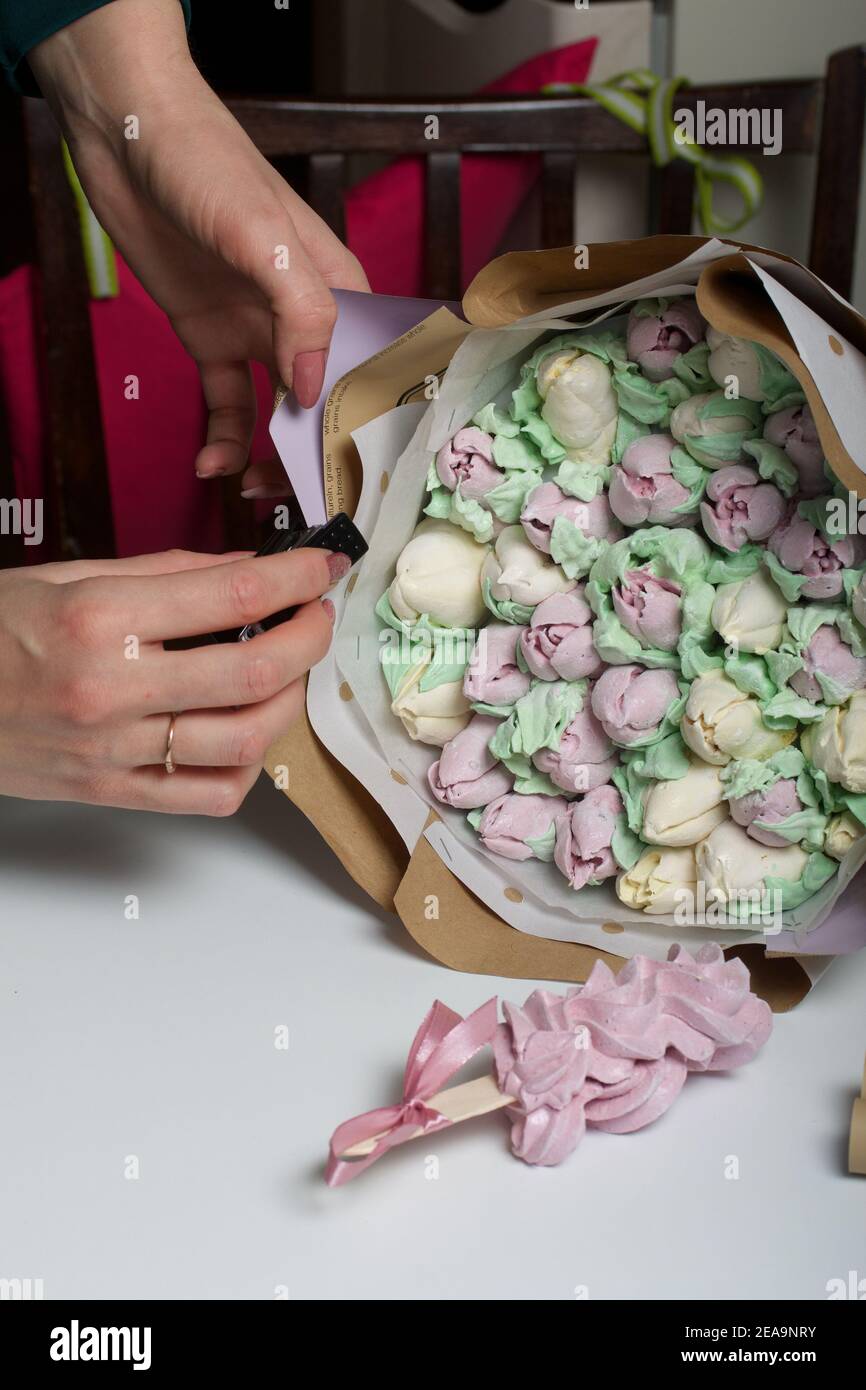 Woman makes a marshmallow bouquet. Marshmallow tulips are collected in ...