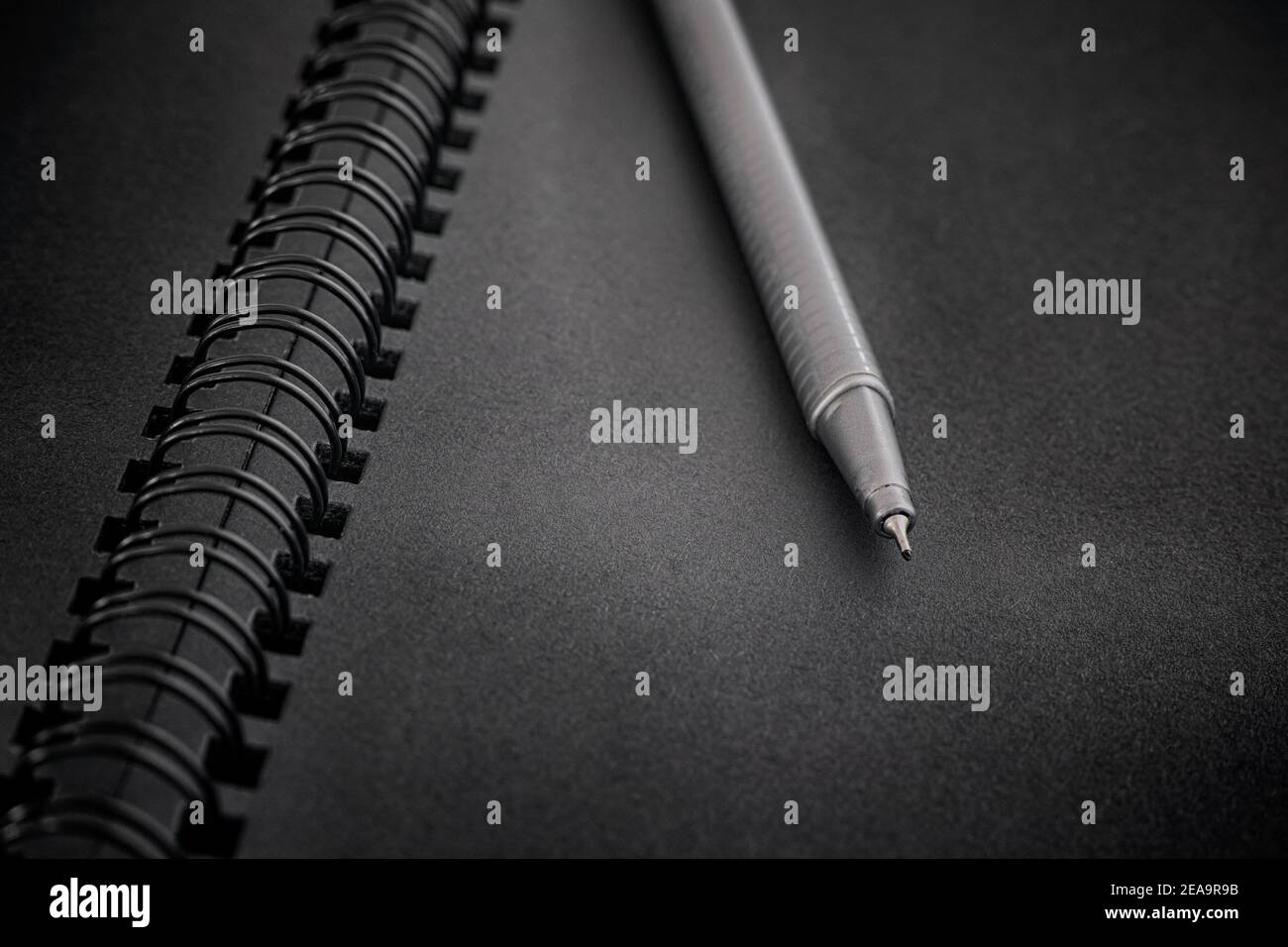 Black spiral notebook and ballpoint pen on it. Close up. Low key Stock ...