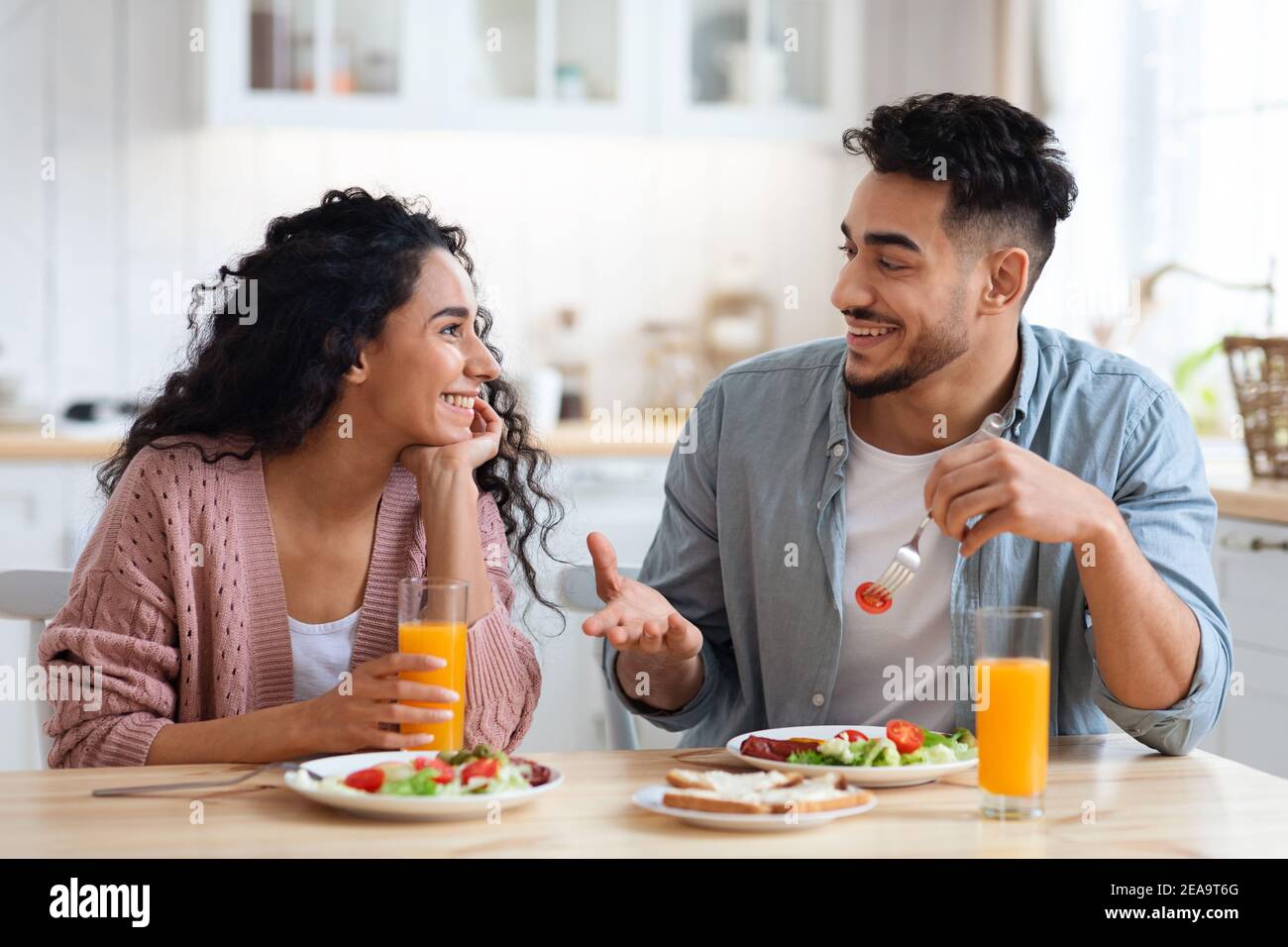 Romantic millennial arab couple eating tasty breakfast together in ...