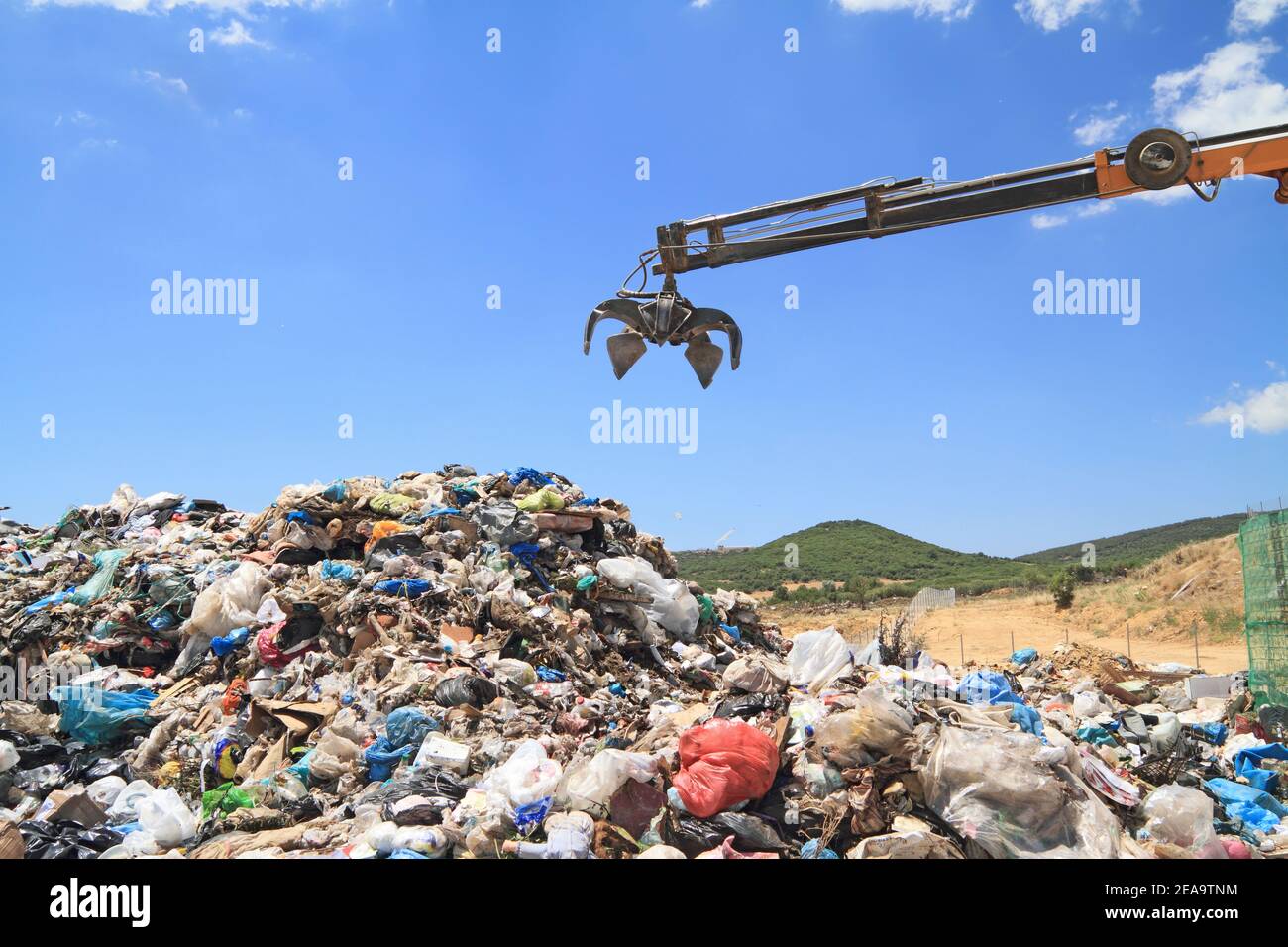 Grabber crane working in landfill Stock Photo - Alamy