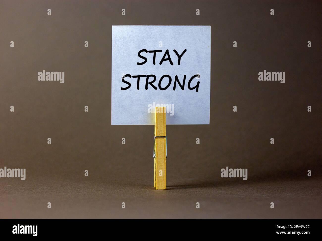Stay strong symbol. Wooden clothespin with white sheet of paper. Words ...