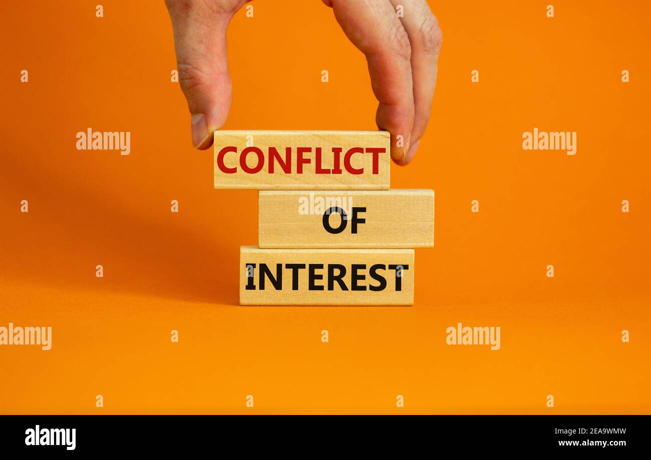 Conflict of interest symbol. Businessman hand. Wooden blocks with words ...